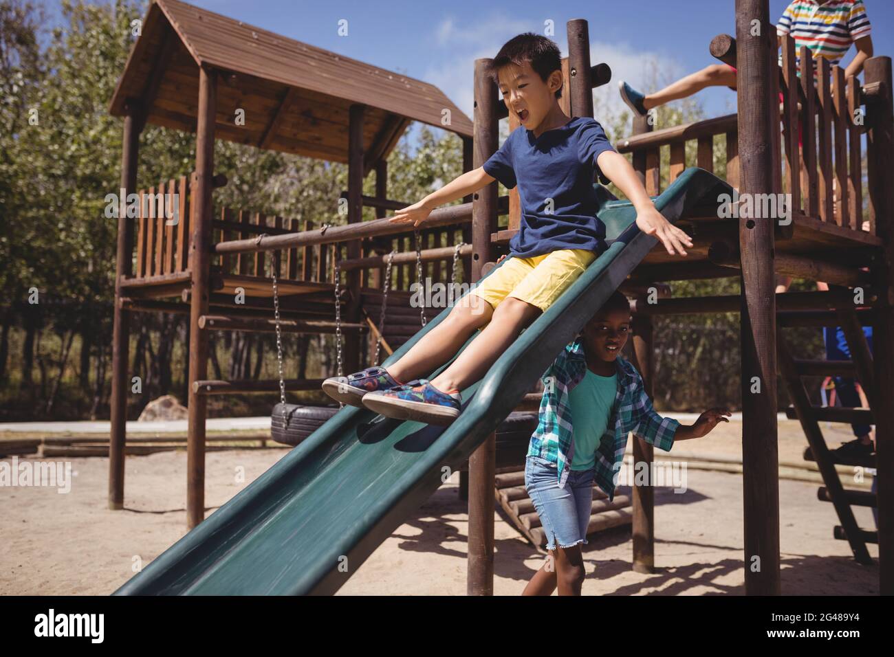 Kids playing on slide Stock Photo - Alamy