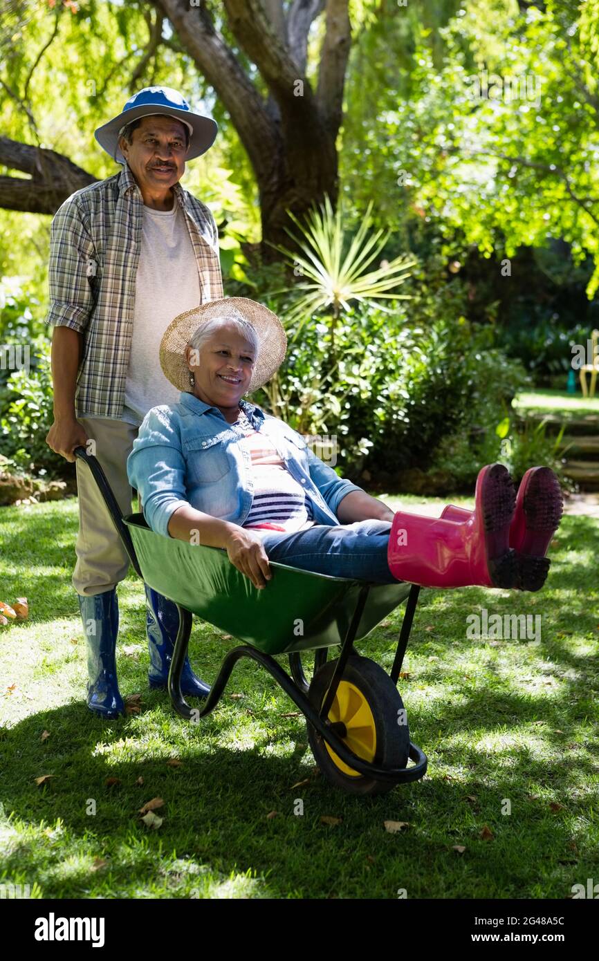 Senior man giving woman ride in wheelbarrow Stock Photo - Alamy