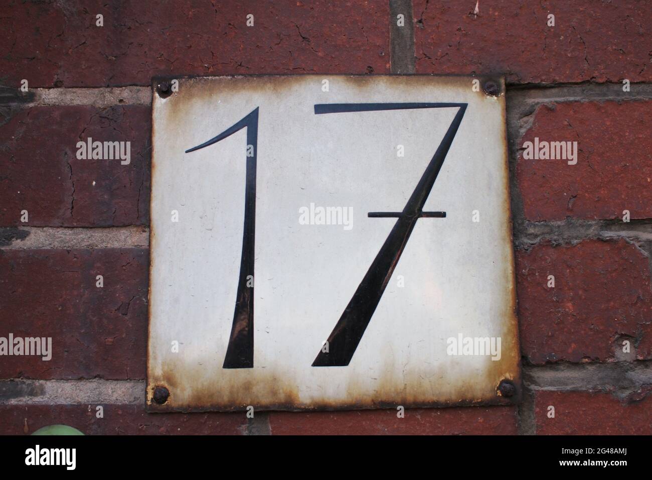 House number "17" attached to a brick wall Stock Photo - Alamy