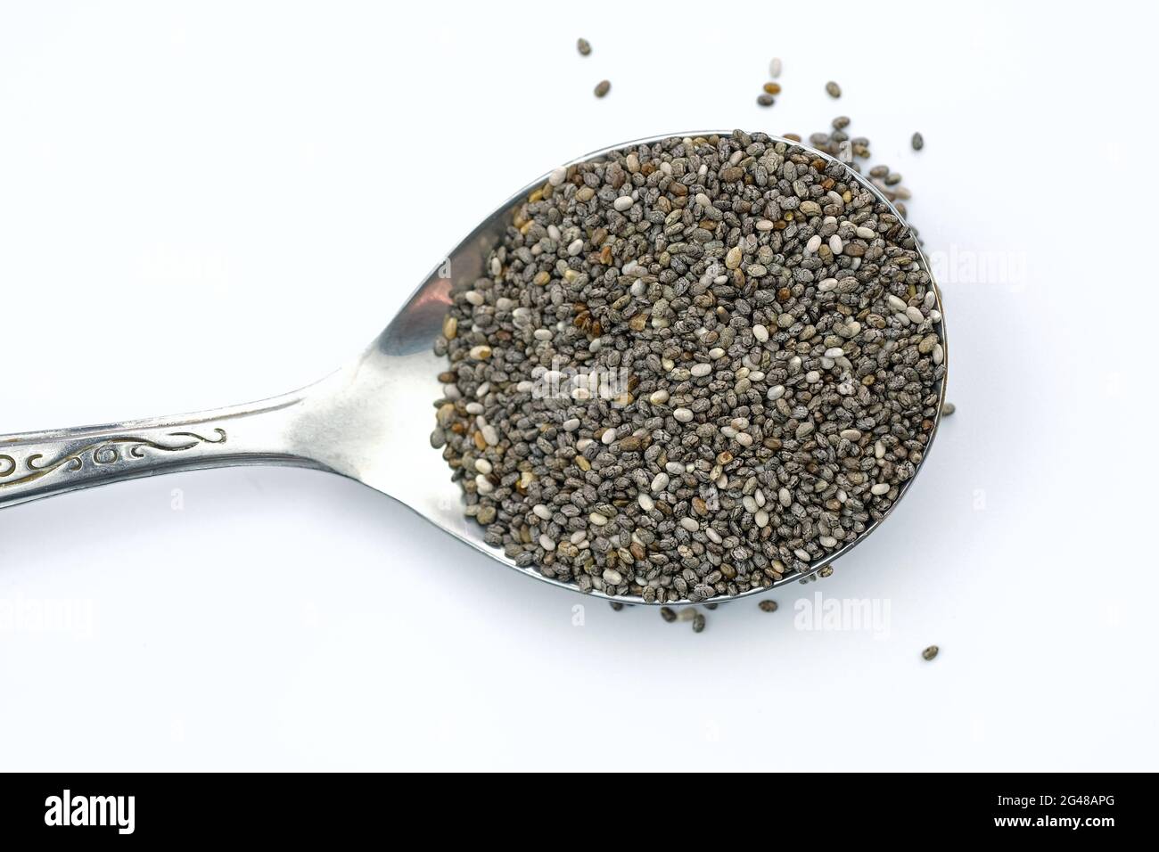 Raw chia seeds in a spoon on a white background. Chia seeds top view ...