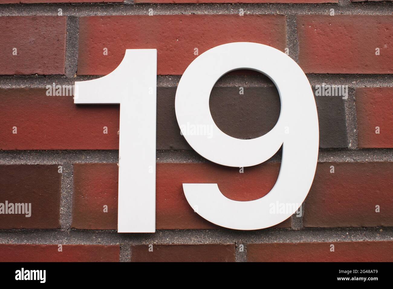 House number "19" attached to a brick wall Stock Photo - Alamy