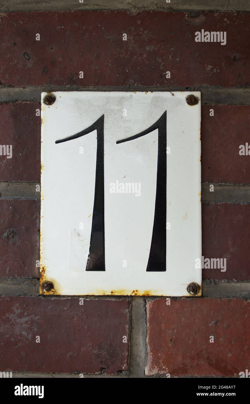 House number "11" attached to a brick wall Stock Photo - Alamy