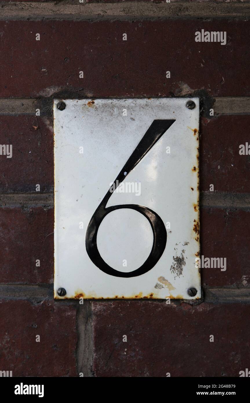 House number "6" attached to a brick wall Stock Photo - Alamy