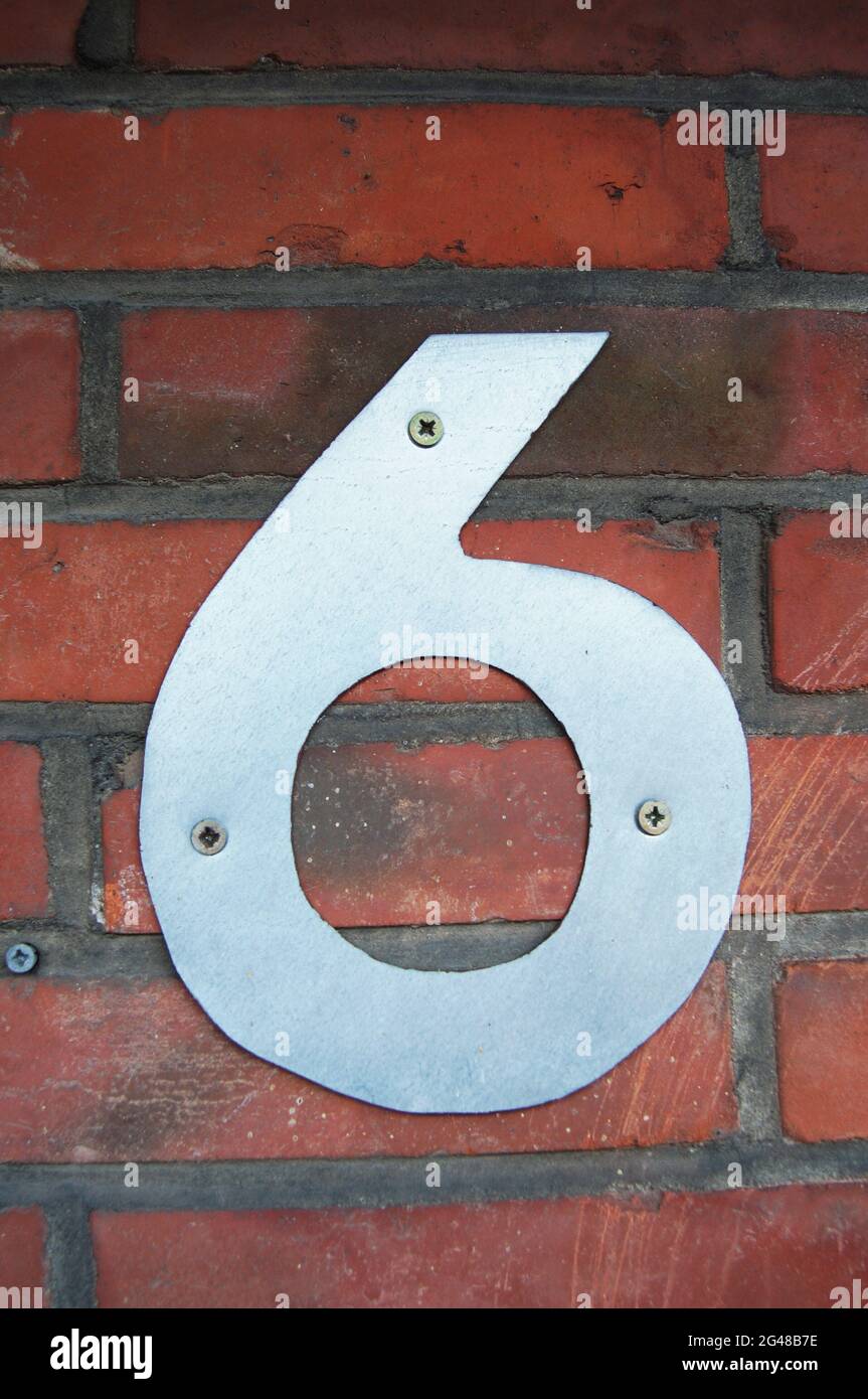 House number "6" attached to a brick wall Stock Photo - Alamy