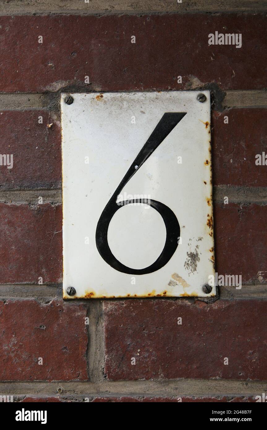 House number "6" attached to a brick wall Stock Photo - Alamy