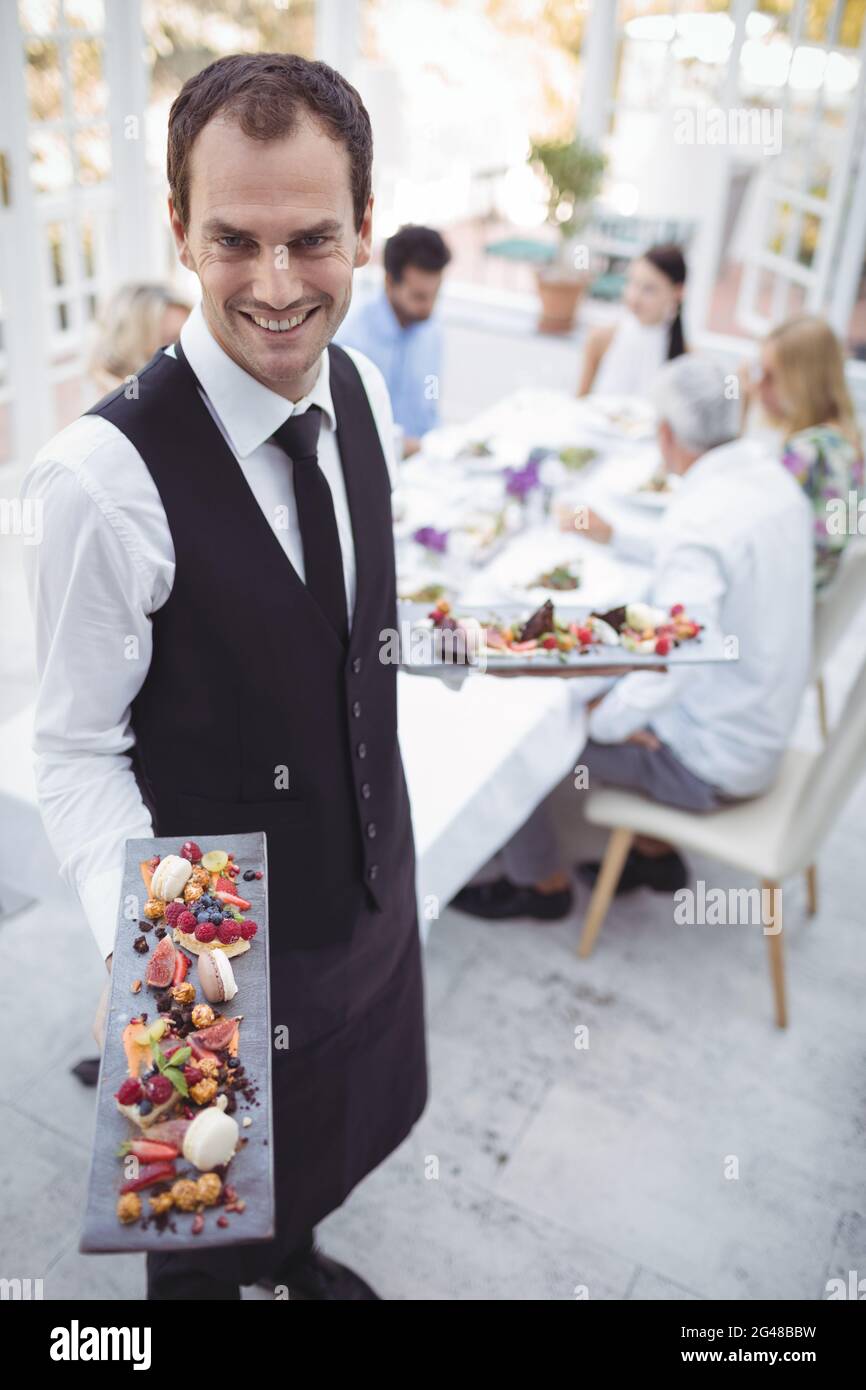 Portrait of smiling waiter holding food tray Stock Photo - Alamy