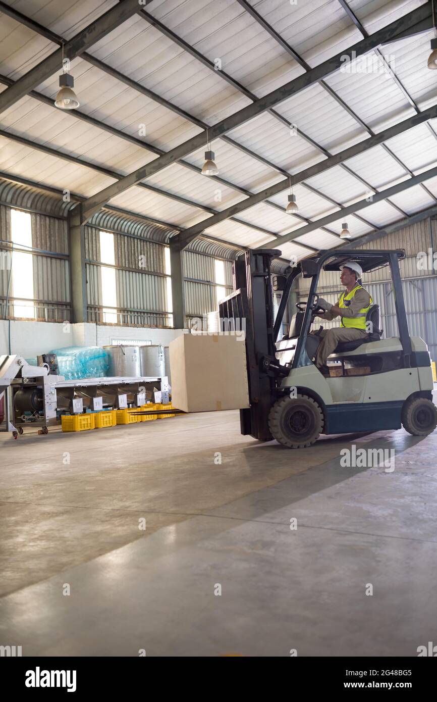 Worker carrying package with forklift Stock Photo - Alamy