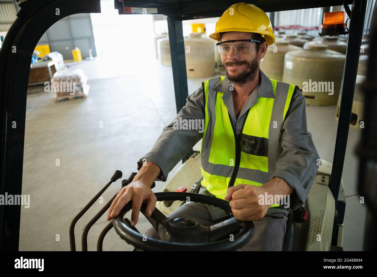 Smiling worker driving a forklift car Stock Photo - Alamy