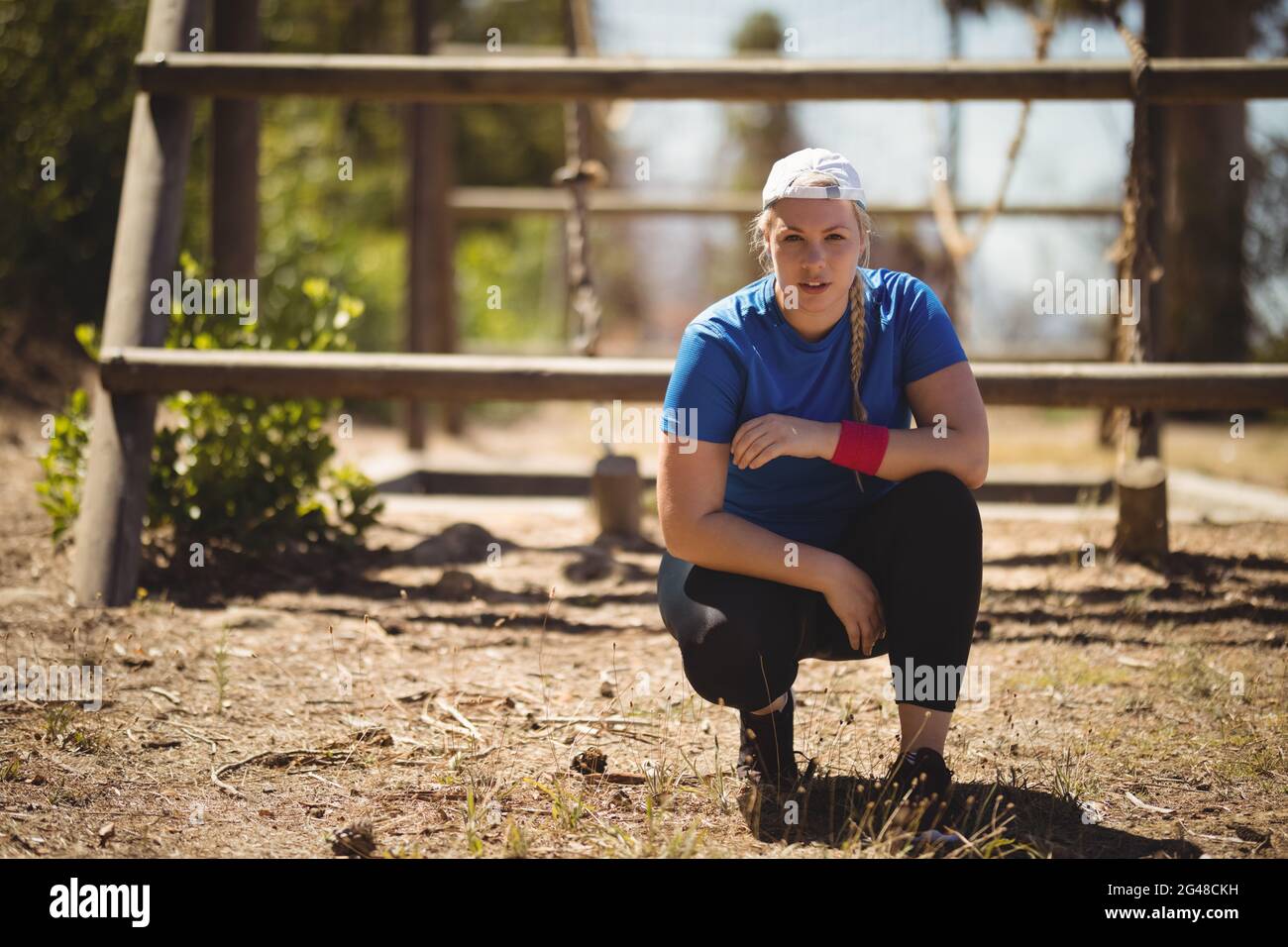 Portrait of confident woman crouching in boot camp Stock Photo - Alamy