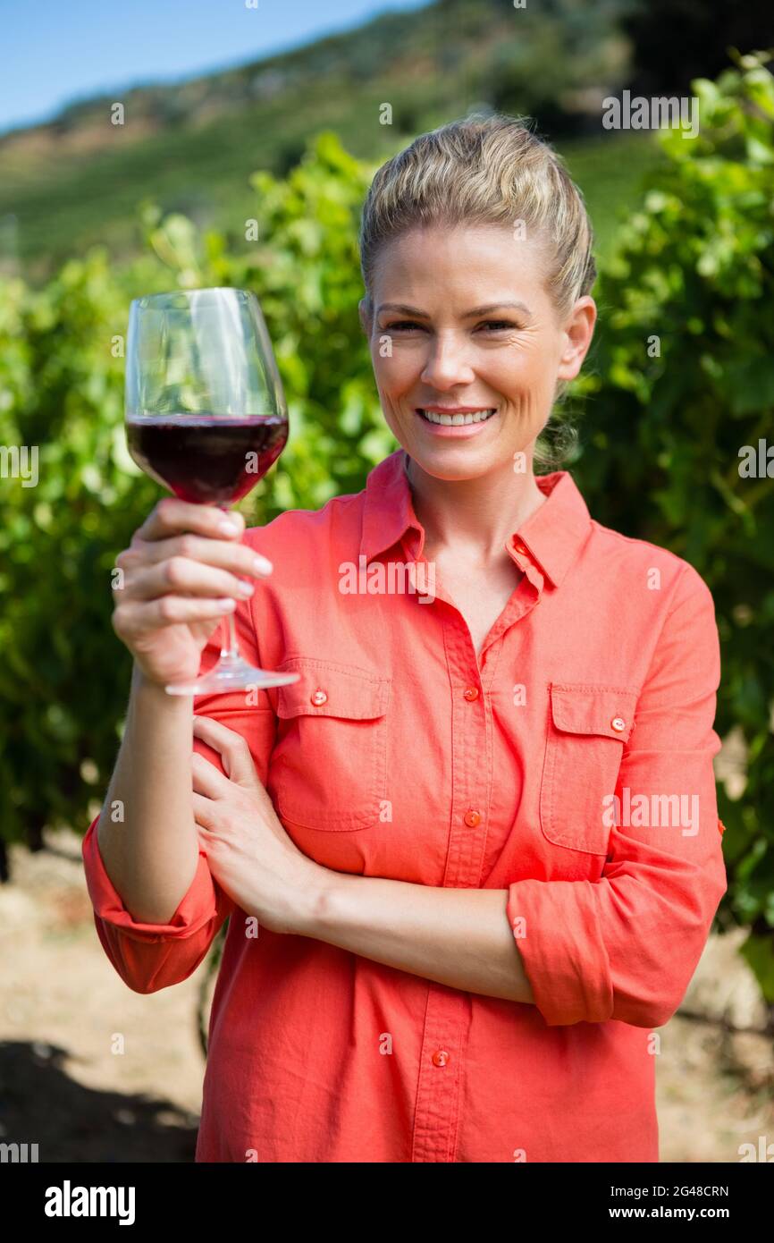Portrait of female vintner holding glass of wine Stock Photo - Alamy