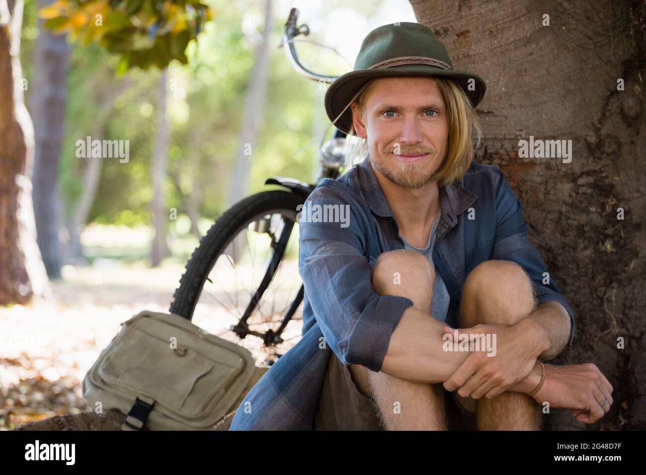 Man sitting against tree trunk hi-res stock photography and images - Alamy