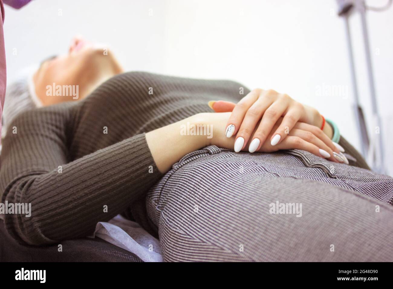 A female patient on examination couch in ultrasound diagnostic cabinet ...