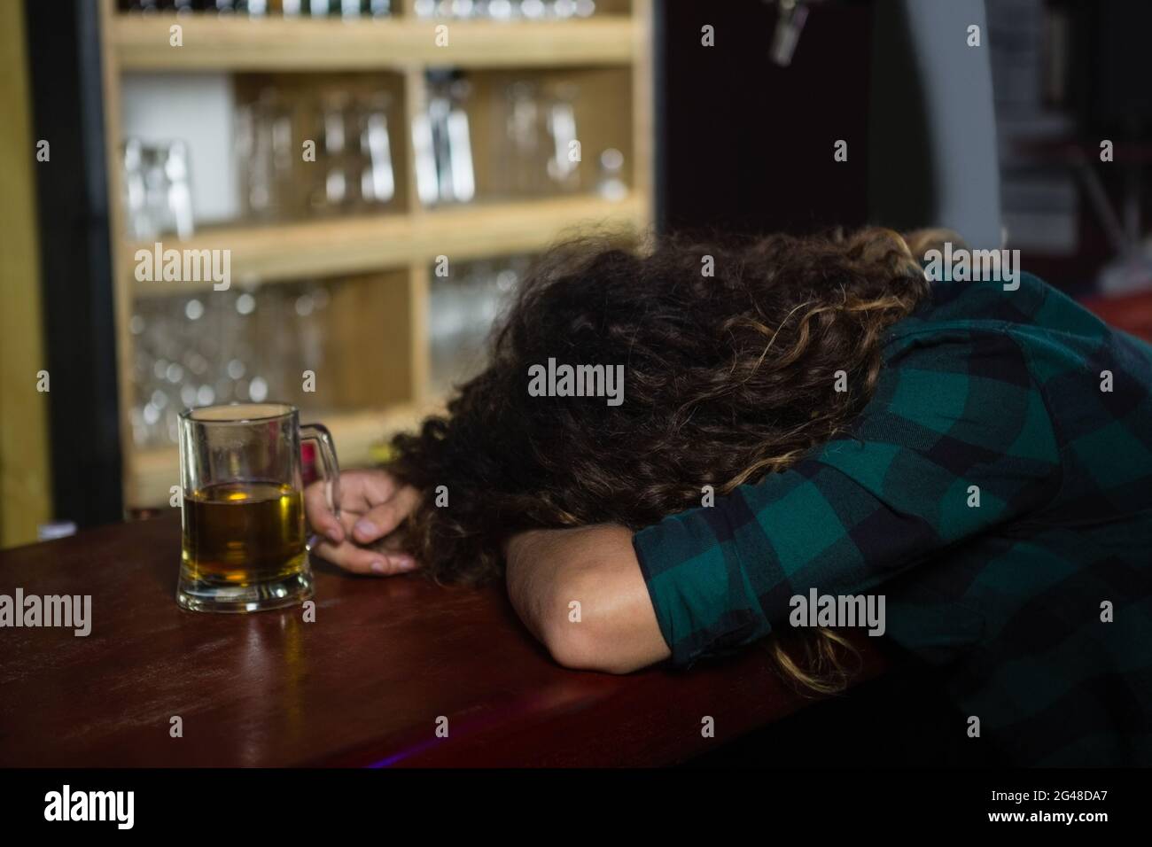 Man sleeping on bar counter Stock Photo - Alamy