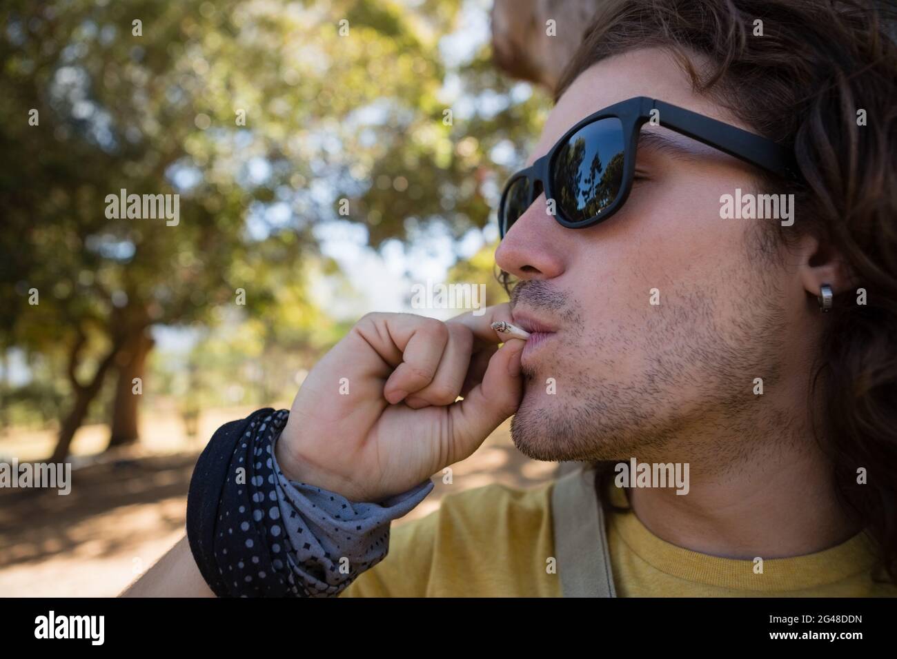 Man smoking weed in the park Stock Photo - Alamy