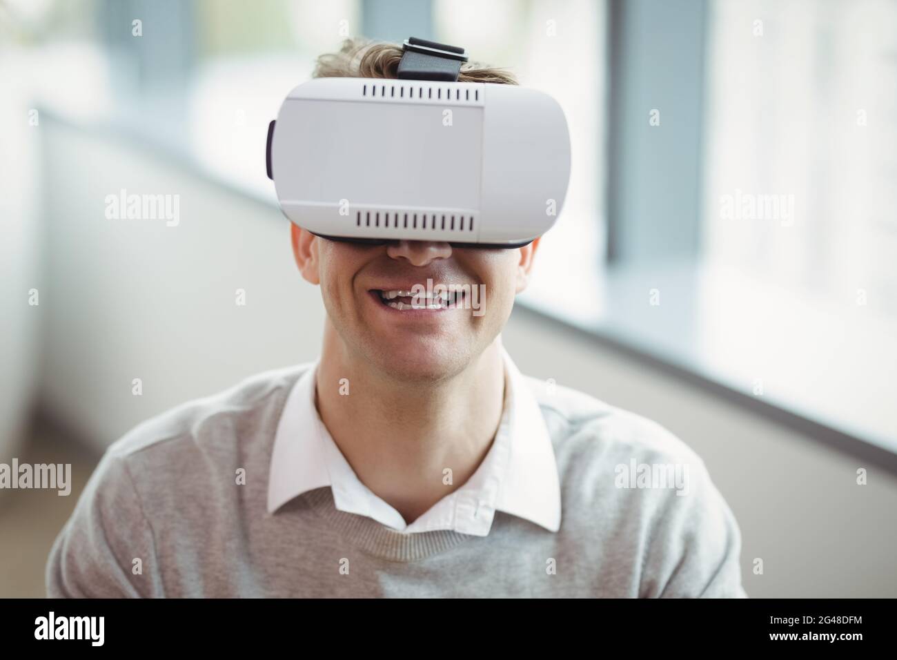 Happy executive using virtual reality headset Stock Photo - Alamy