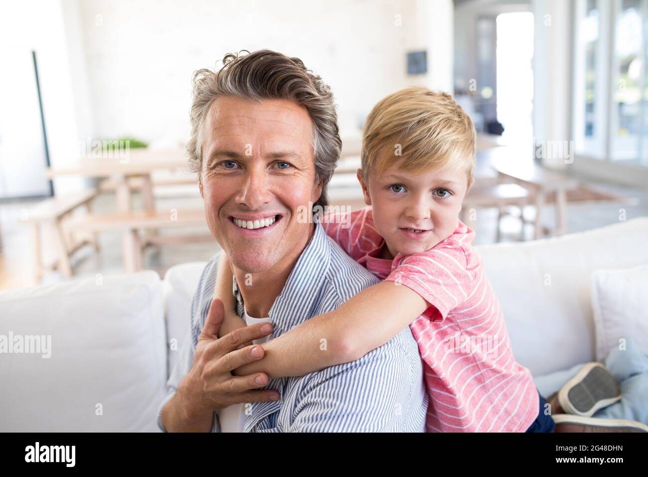 Happy father and son relaxing on sofa in living room Stock Photo - Alamy