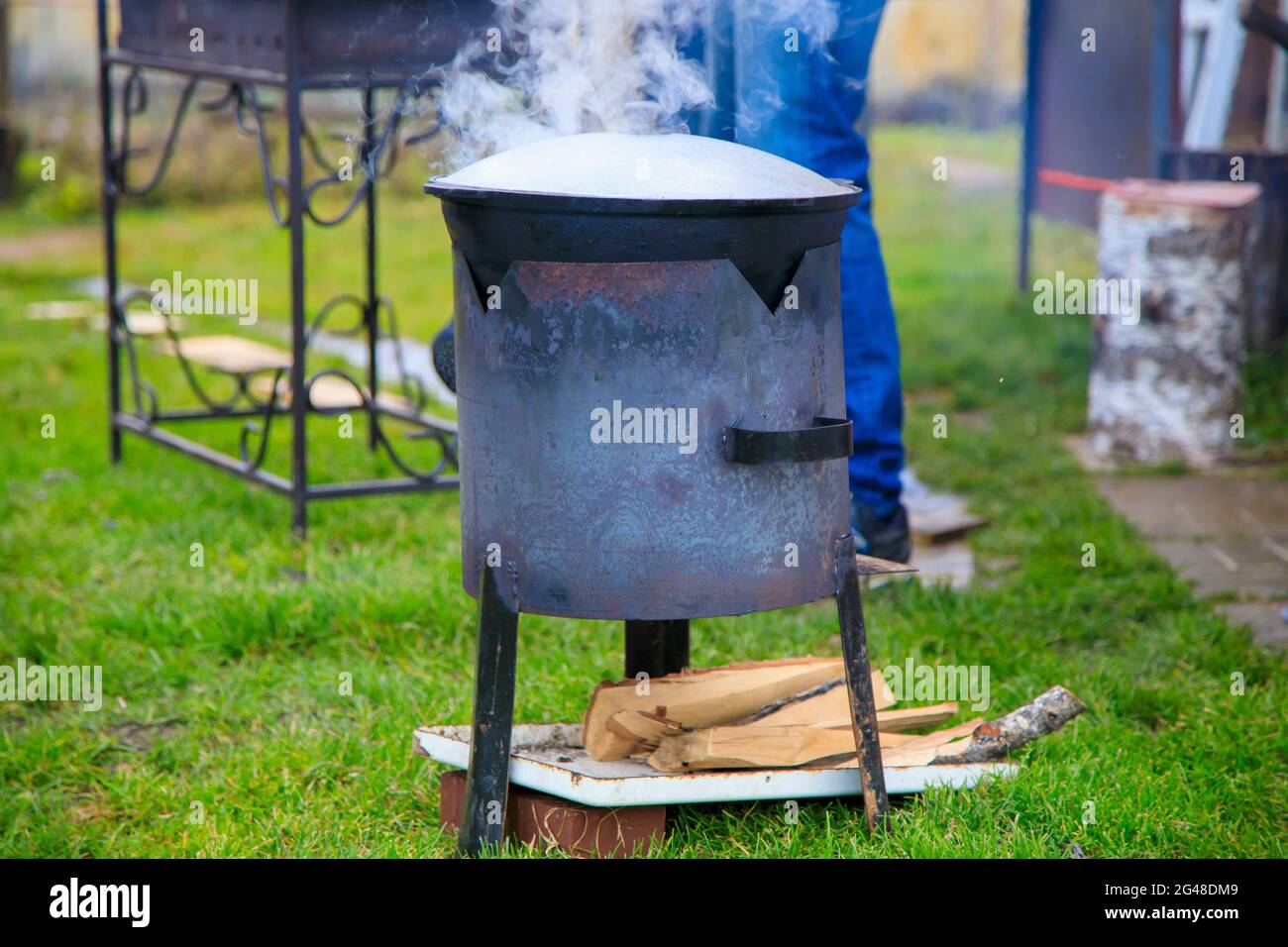 Cooking in a cauldron on the fire. Picnic outdoors in summer. Close-up ...