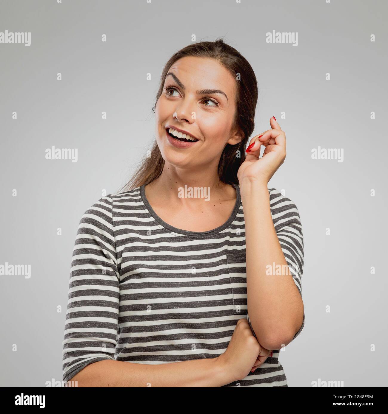 Portrait of a woman with a expression of having an idea. overa gray ...