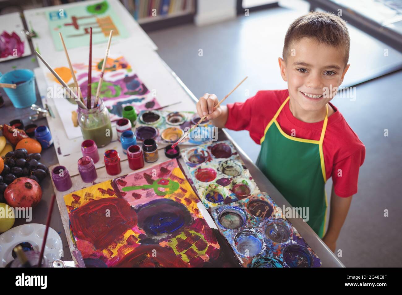 High angle portrait of boy painting at desk Stock Photo - Alamy