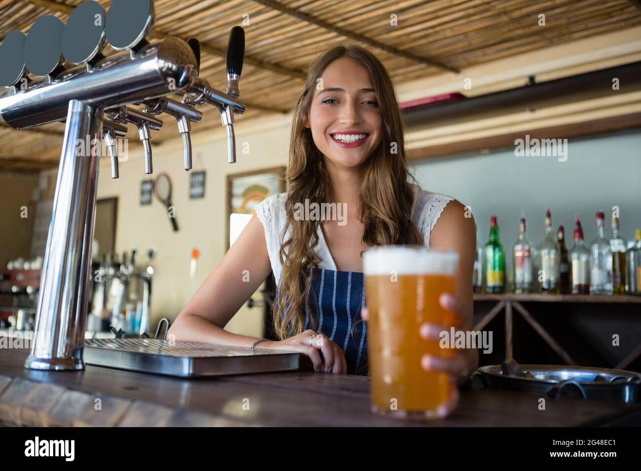 Portrait of happy barmaid holding beer glass Stock Photo - Alamy