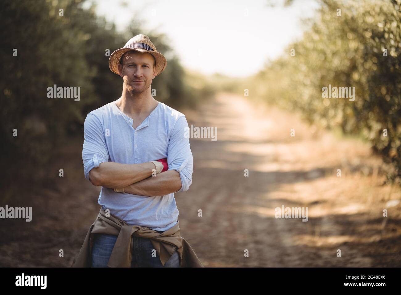 Confident young man standing on dirt road at farm Stock Photo - Alamy