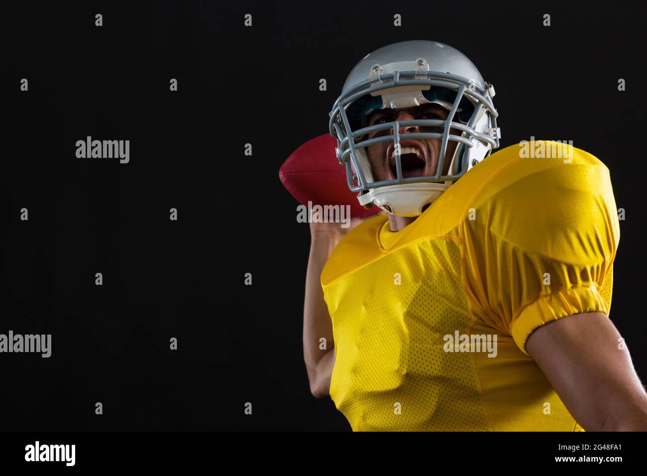 Energetic American football player holding a ball in one hand Stock ...
