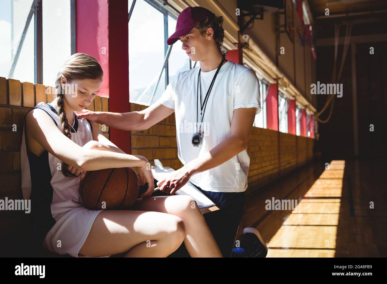 Male coach talking to female basketball player Stock Photo - Alamy