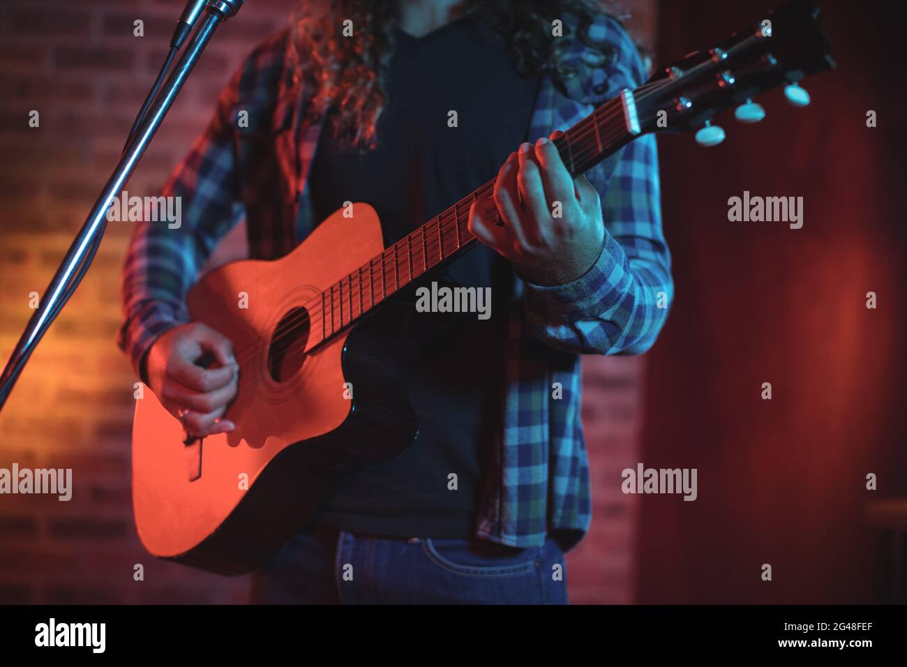 Mid section of singer playing guitar while singing Stock Photo - Alamy