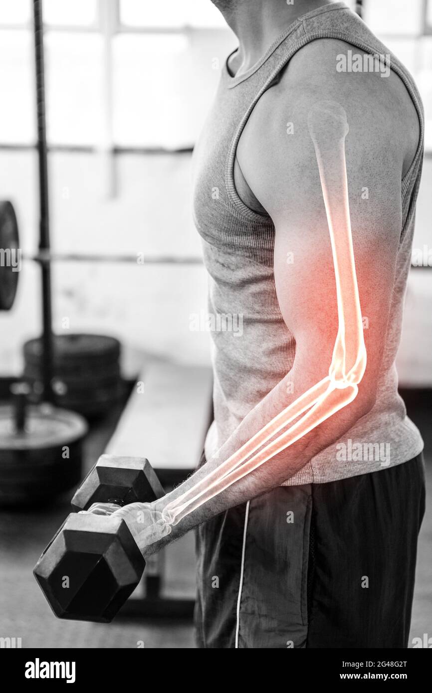 Highlighted arm of strong man lifting weights at gym Stock Photo - Alamy