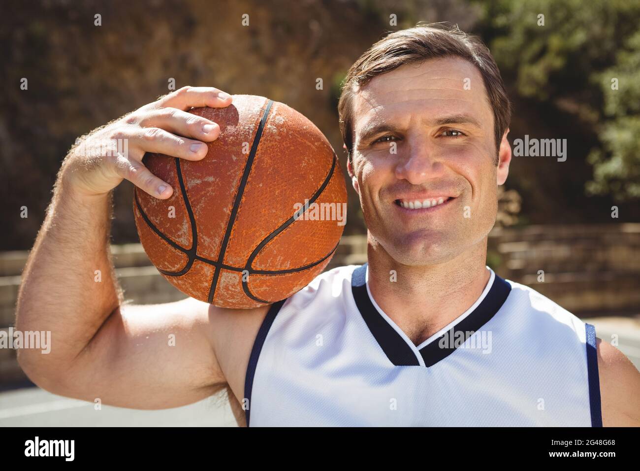 Smiling basketball player with ball Stock Photo - Alamy