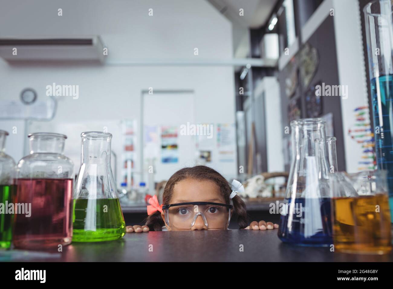 Portrait of elementary student hiding in laboratory Stock Photo - Alamy