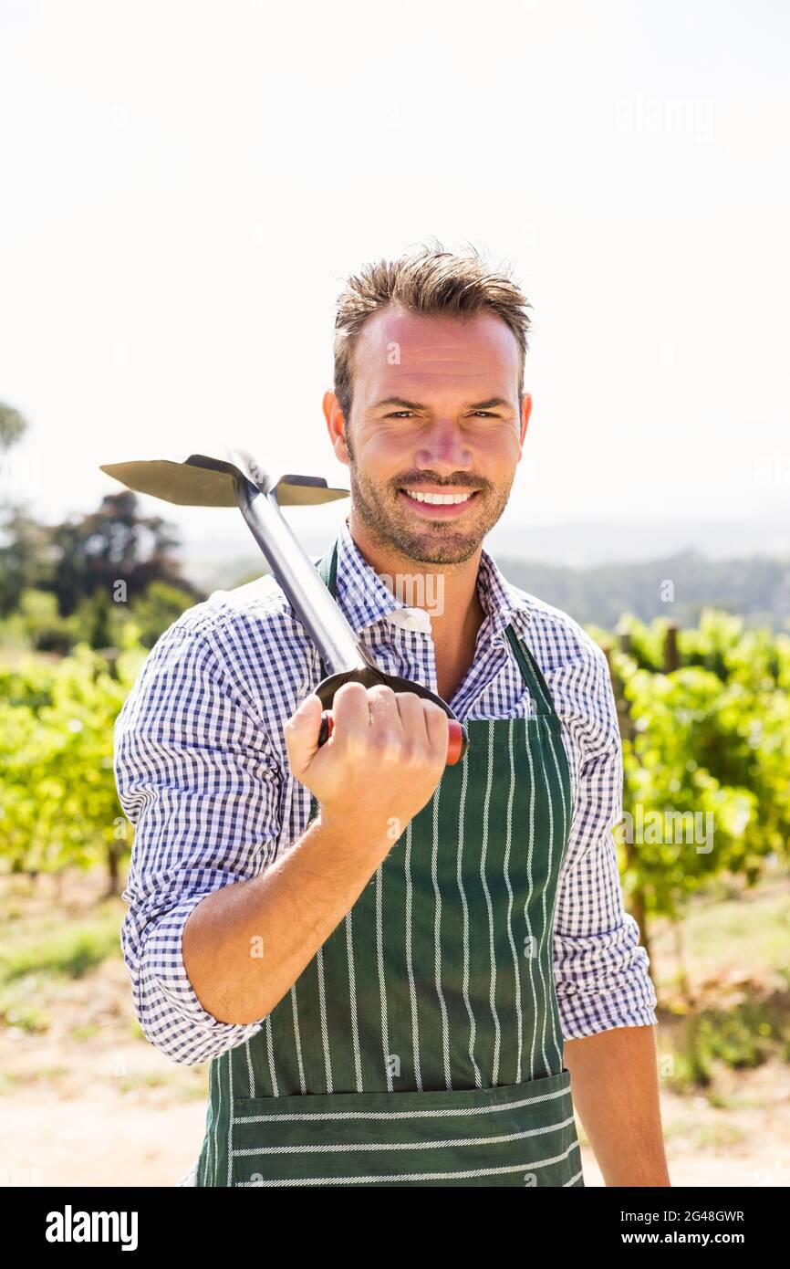 Portrait of handsome man holding shovel at vineyard Stock Photo - Alamy
