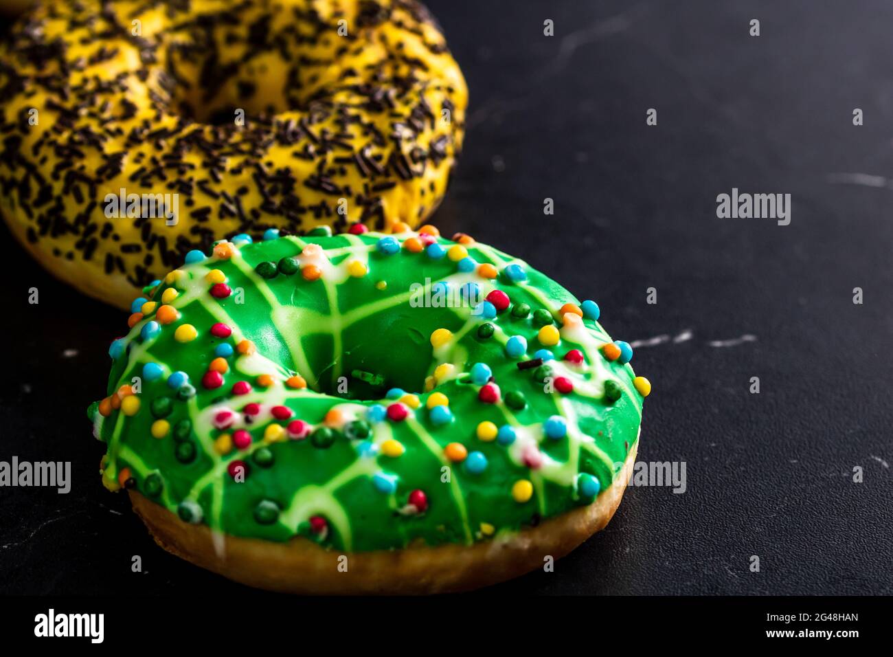 Glazed donuts with sprinkles isolated. Close up of colorful donuts ...