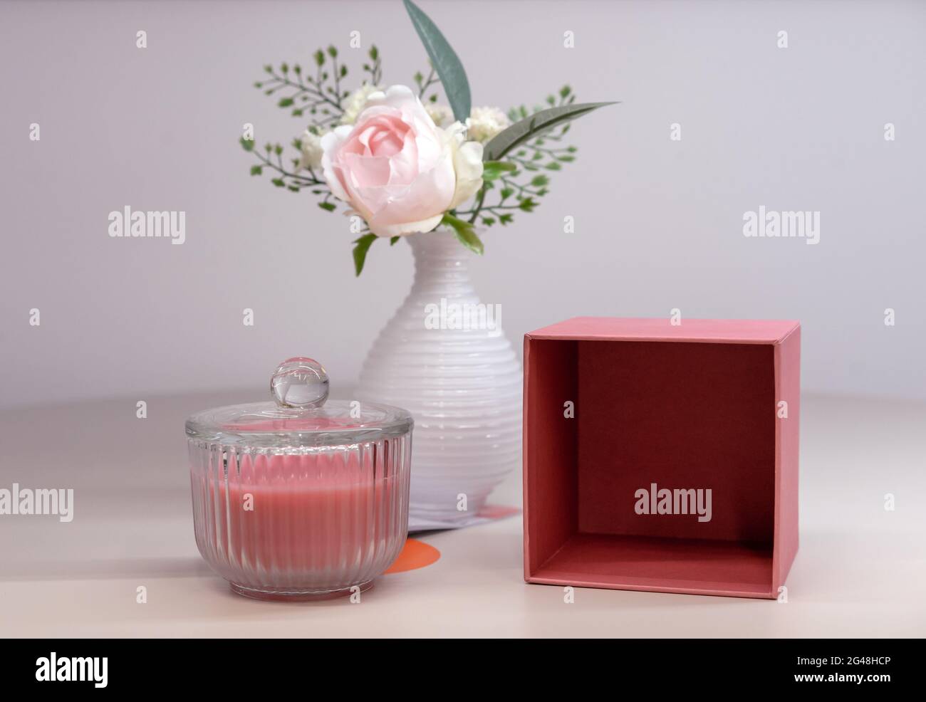 Pink scented candle in a glass candlestick and vase with a flower Stock ...