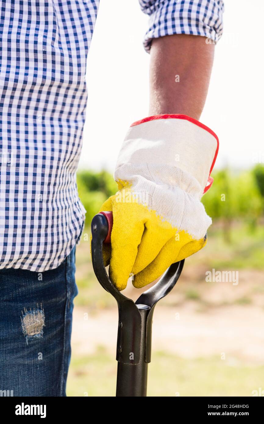 Cropped image of man holding shovel Stock Photo - Alamy