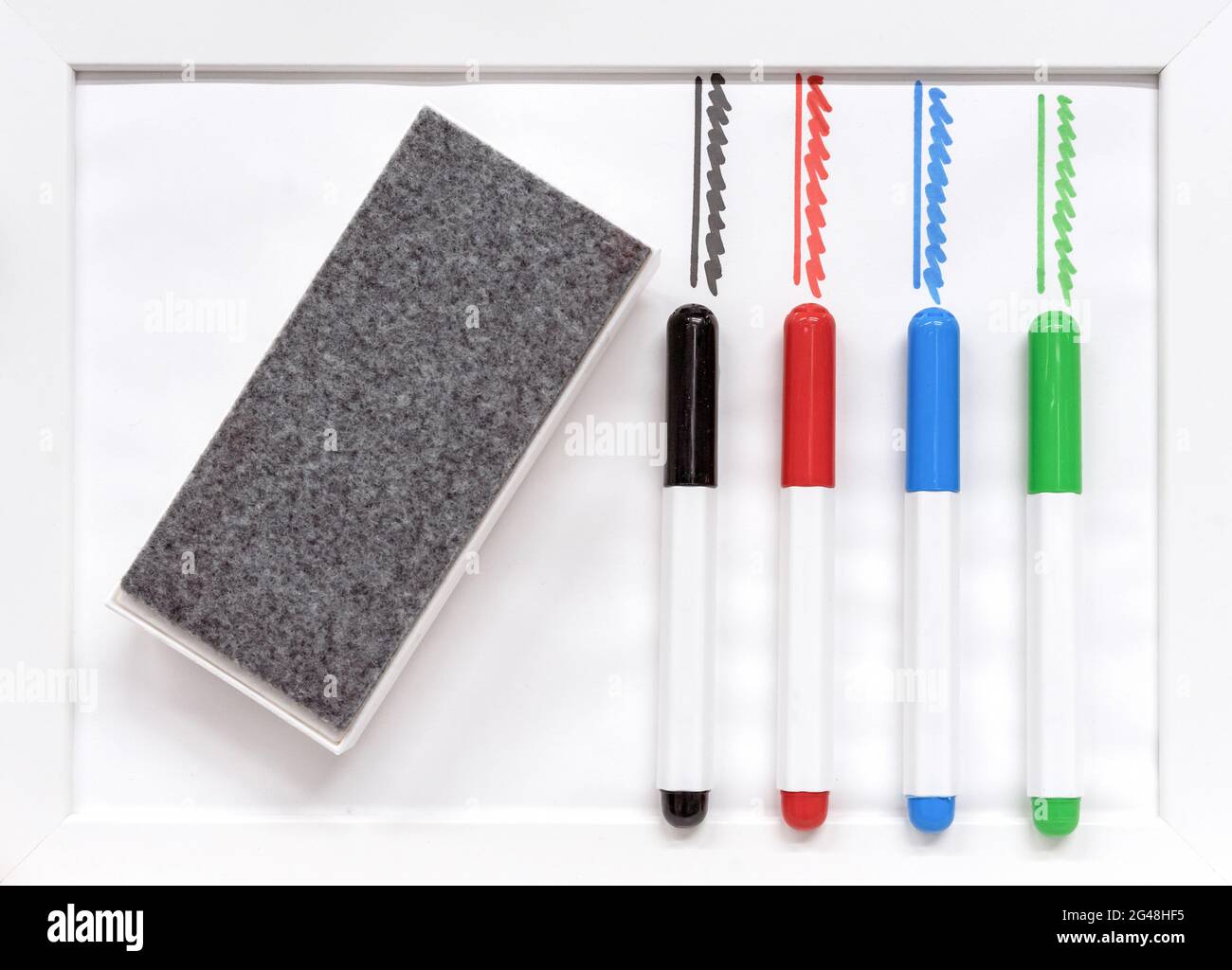 Colored markers and erasing sponge on a white board Stock Photo - Alamy
