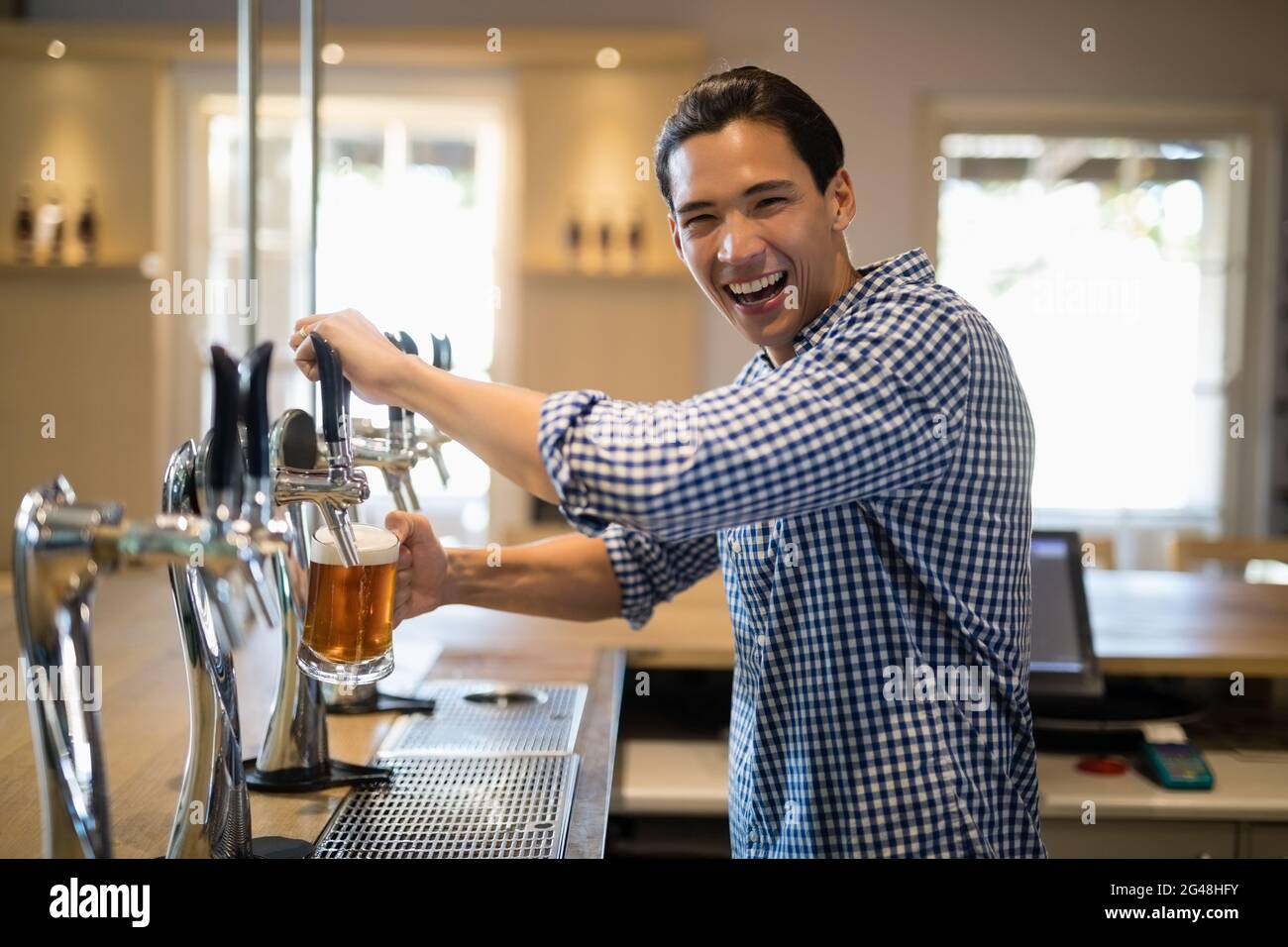 Bar tender filling beer from beer pump Stock Photo - Alamy