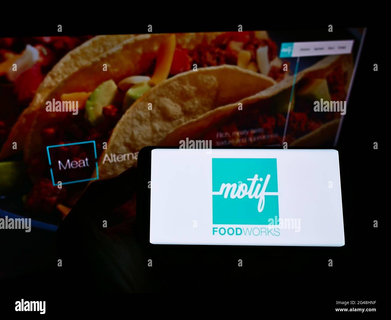 Person holding mobile phone with logo of American food technology ...