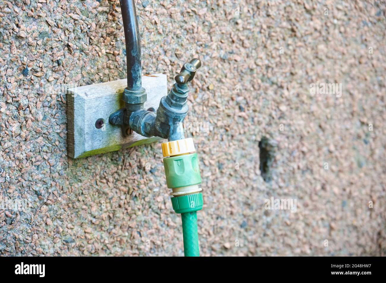 Bib tap outdoors on house external wall to water garden and car Stock ...