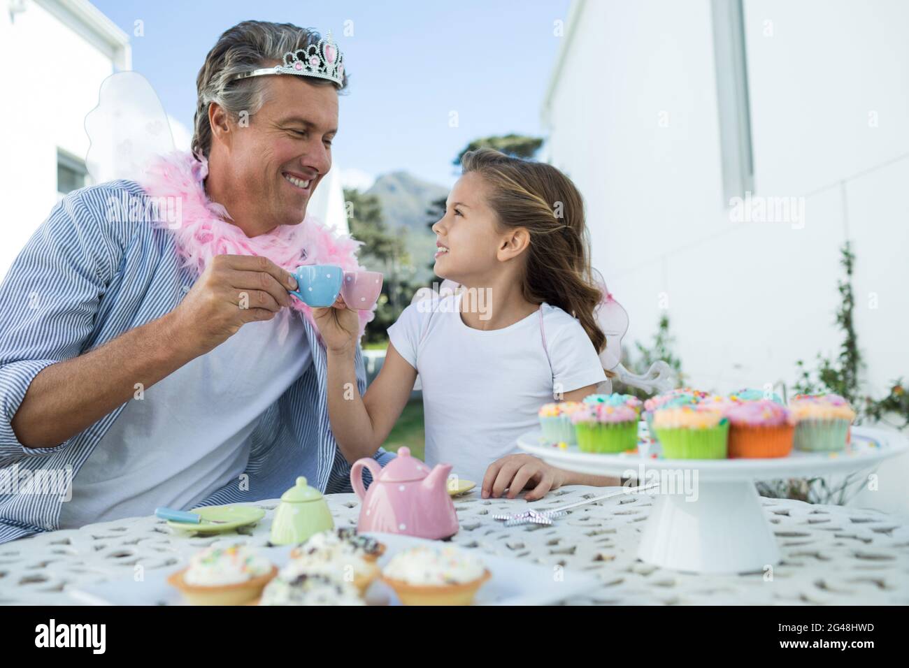 Smiling father and daughter in fairy costume toasting cup of tea Stock ...