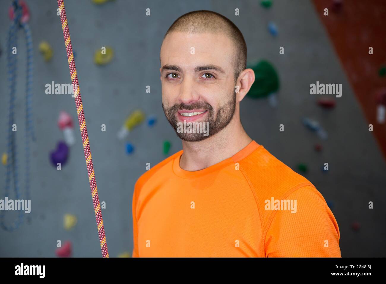 Trainer standing with rope in fitness studio Stock Photo - Alamy