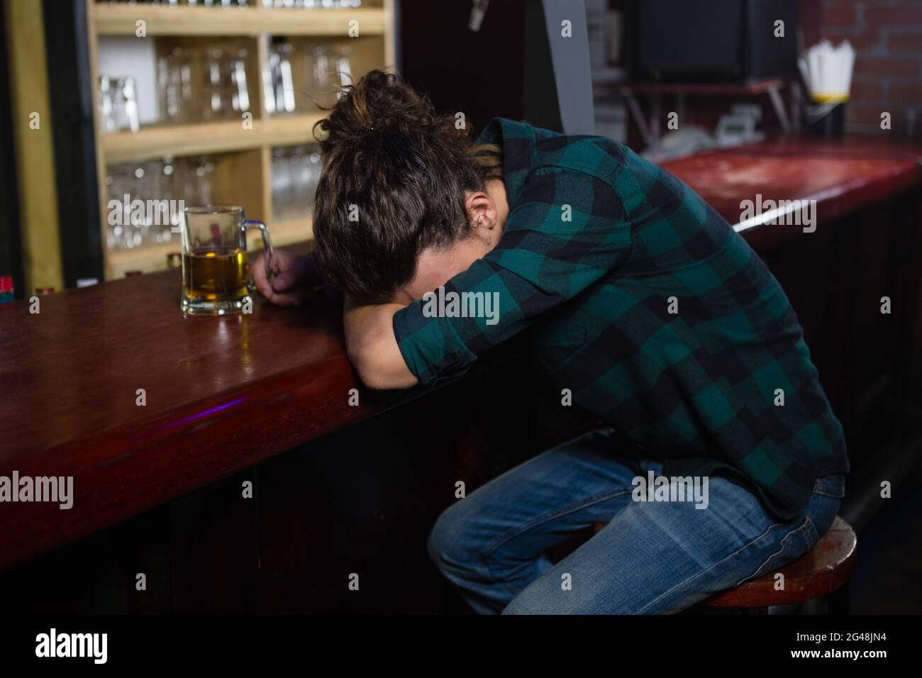 Man sleeping on bar counter Stock Photo - Alamy