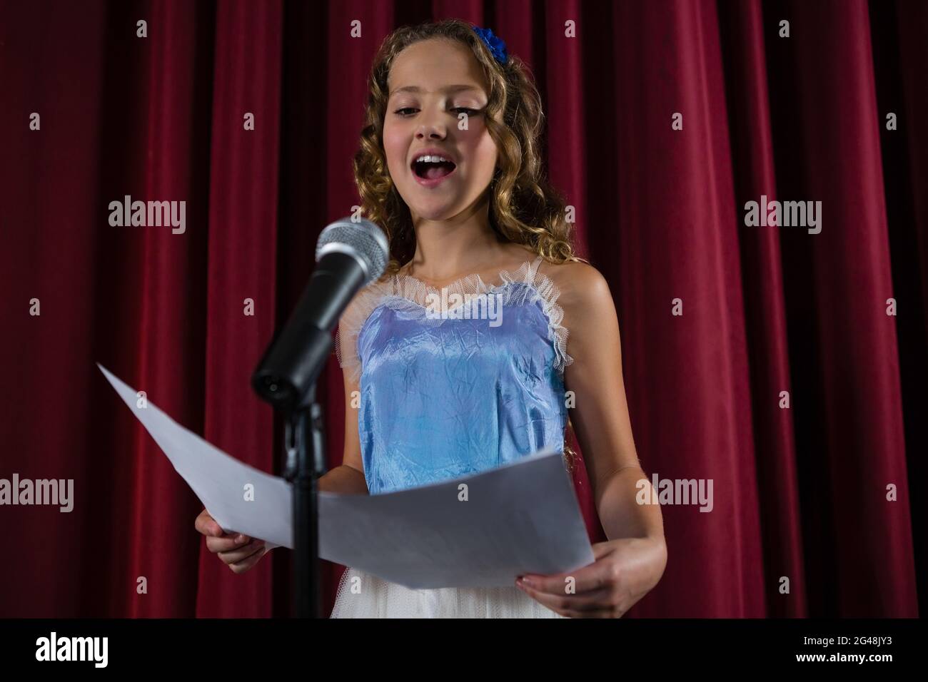 Female artist singing song on stage Stock Photo - Alamy