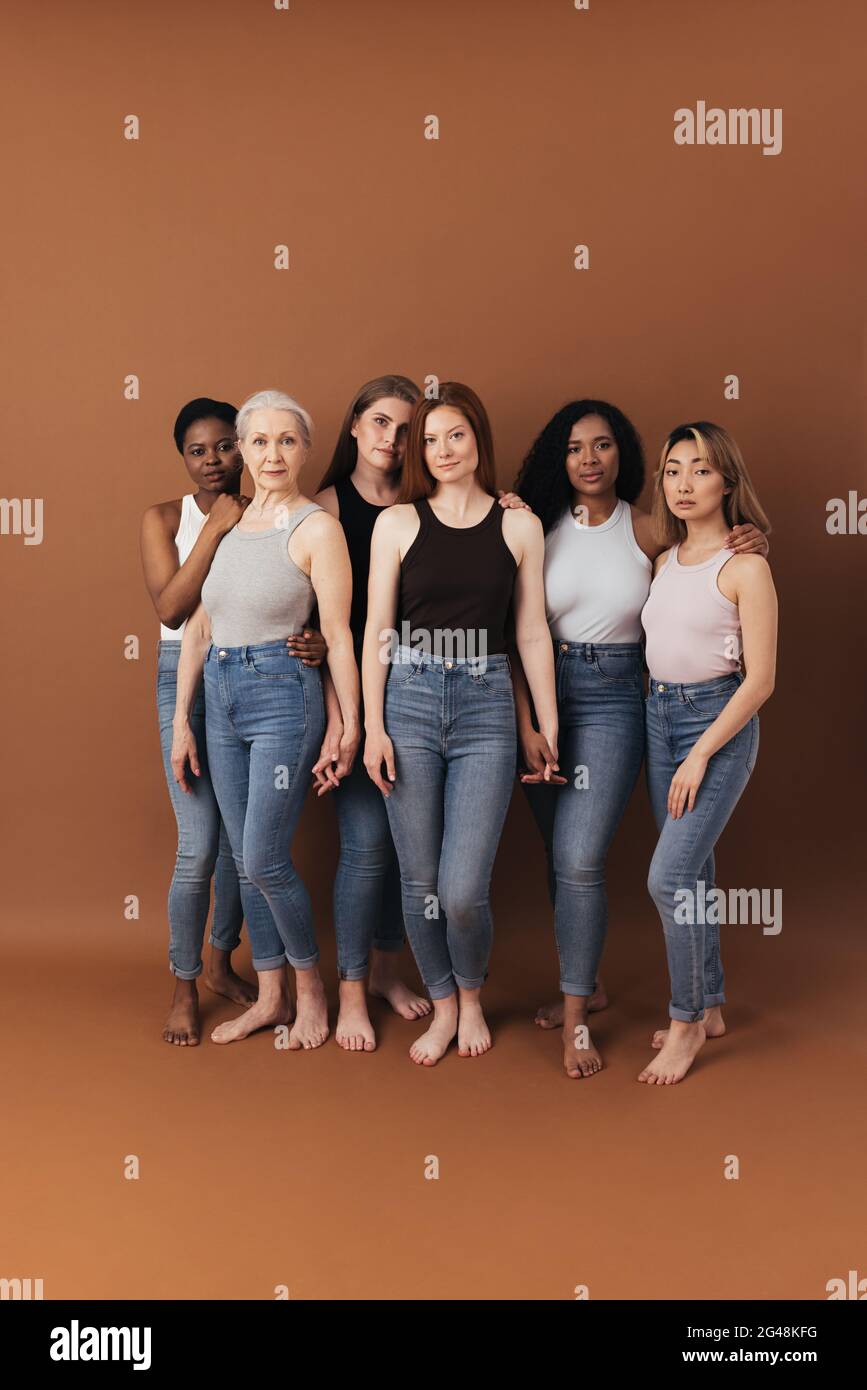 Studio shot of six women standing together holding their hands and ...