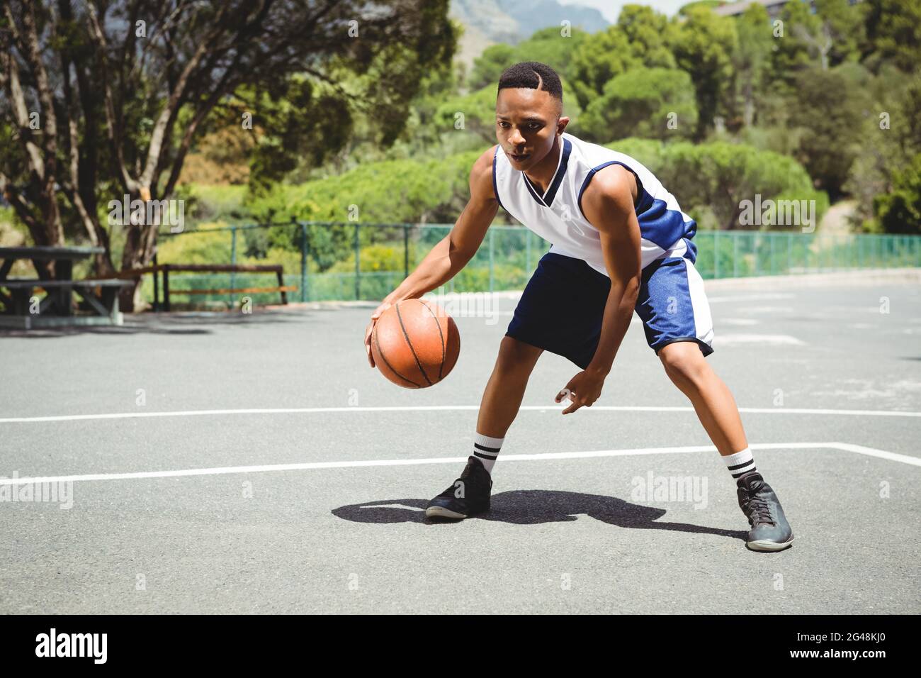 Full length of teenage boy practicing basketball Stock Photo - Alamy