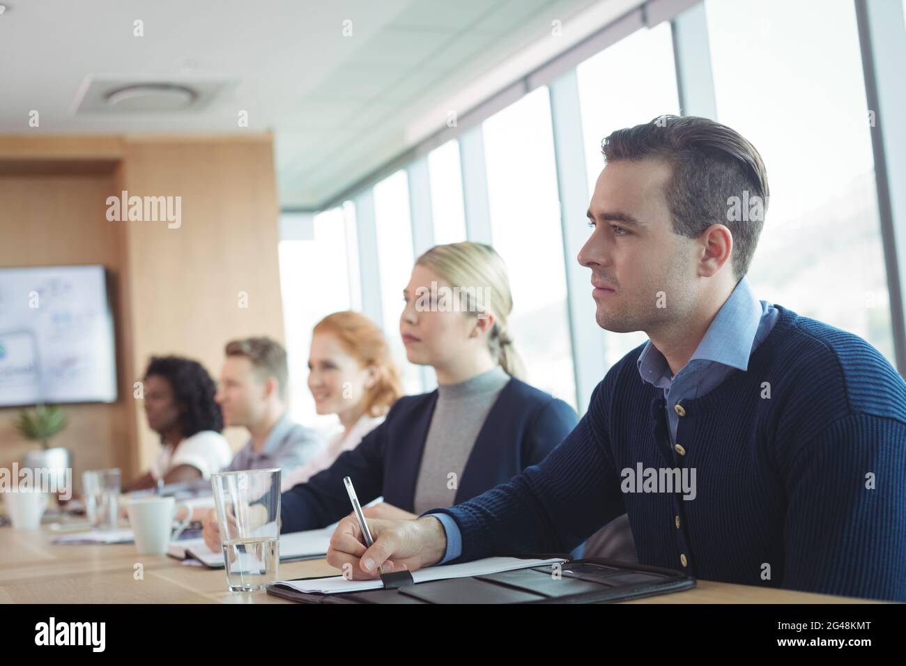 Concentrated business people sitting at conference table during meeting ...