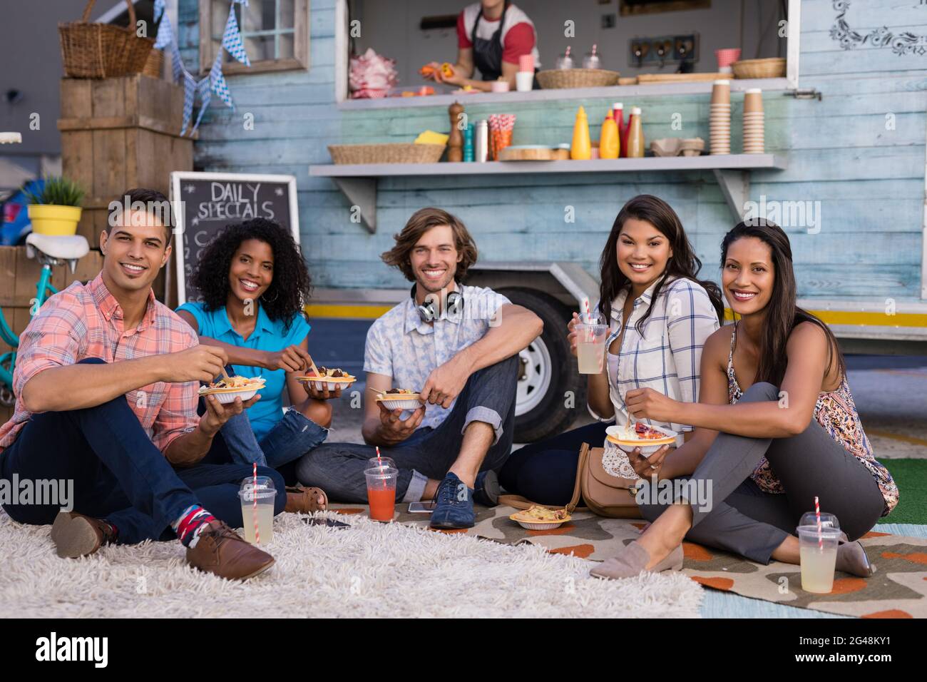 Happy friends interacting while having snacks and juice Stock Photo - Alamy