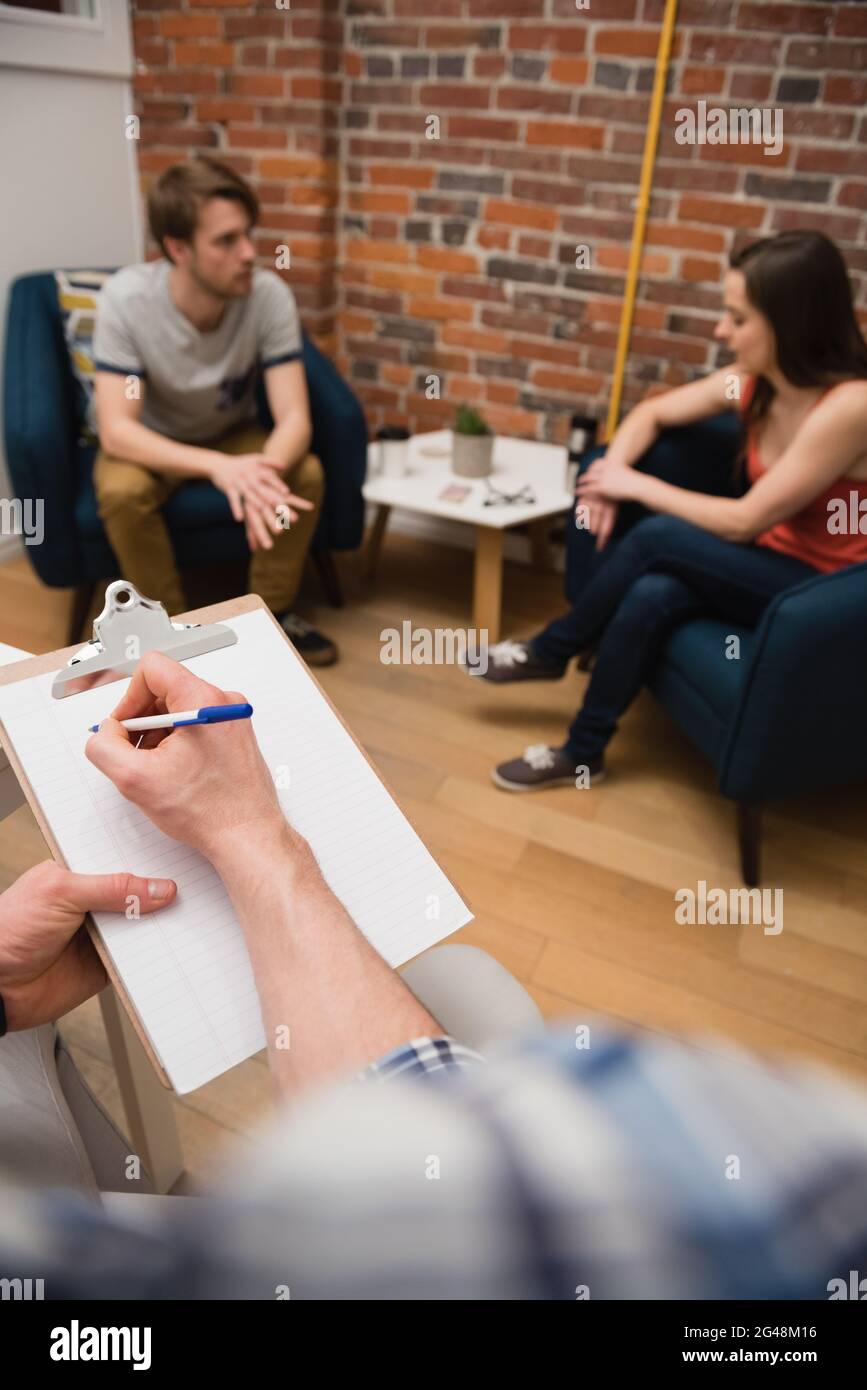 Executive writing on clipboard in office Stock Photo - Alamy