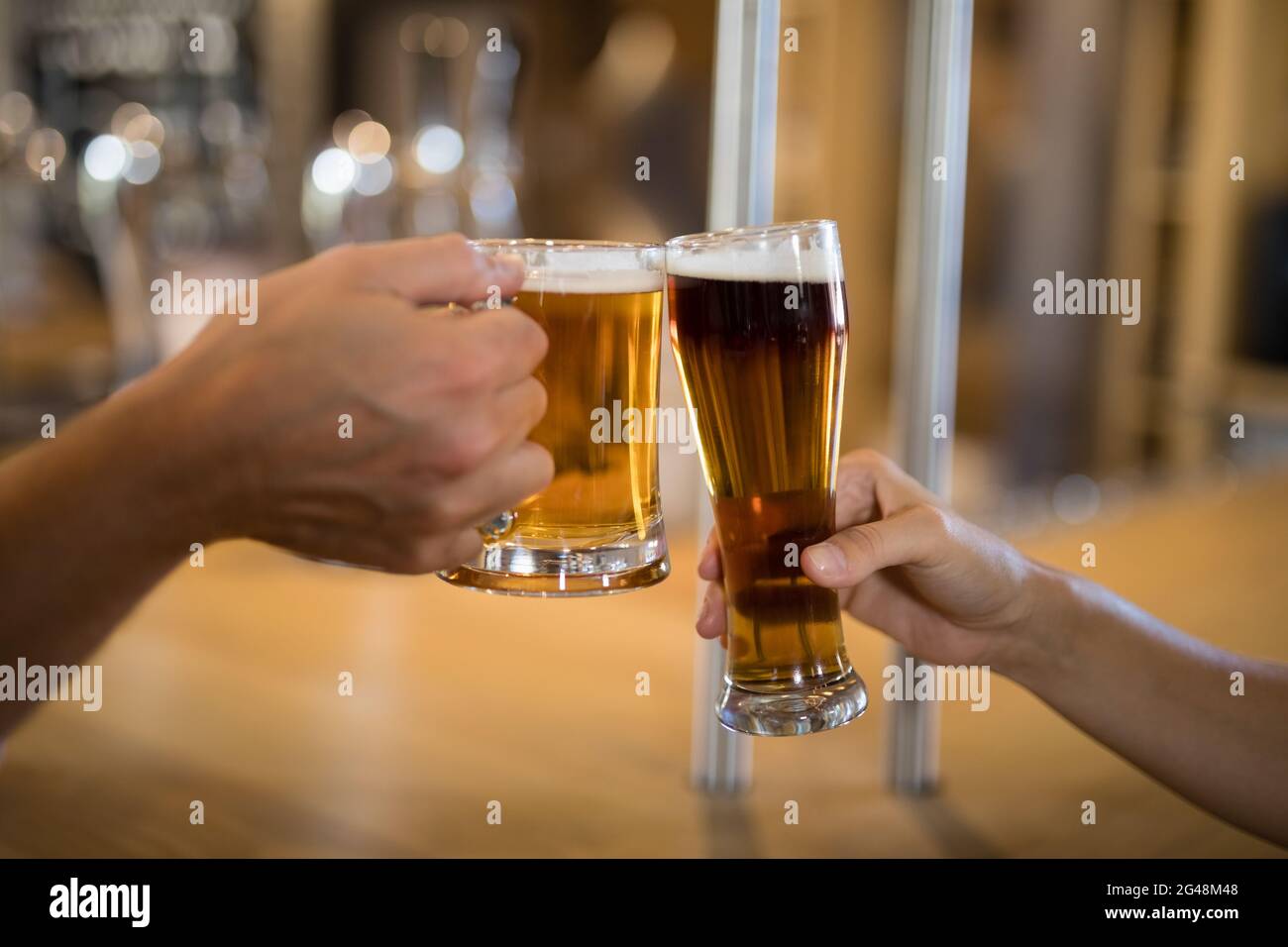 Couple toasting glass of beer at bar counter Stock Photo - Alamy