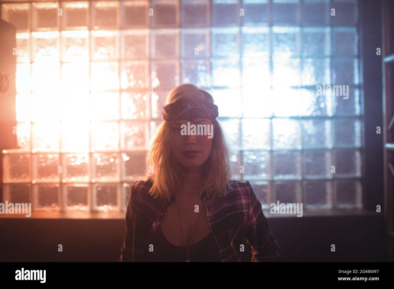 Confident female singer standing against window in nightclub Stock ...